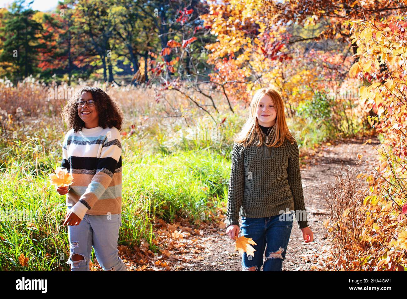 Two pretty tween girls laughing together outdoors in fall colors Stock ...