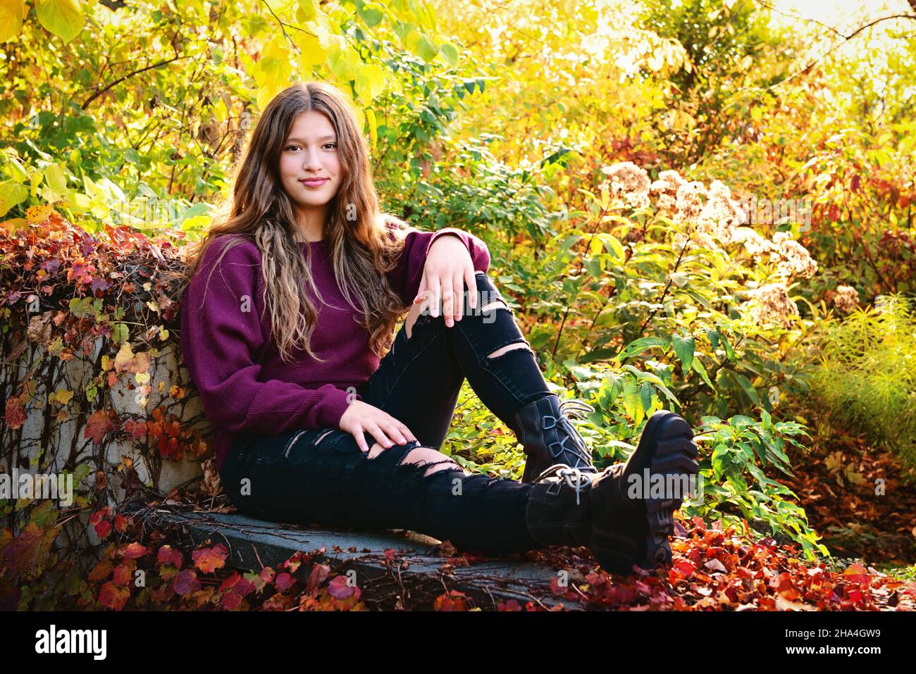 Beautiful Tween Girl With Long Hair Sitting Outdoors In Fall Colors