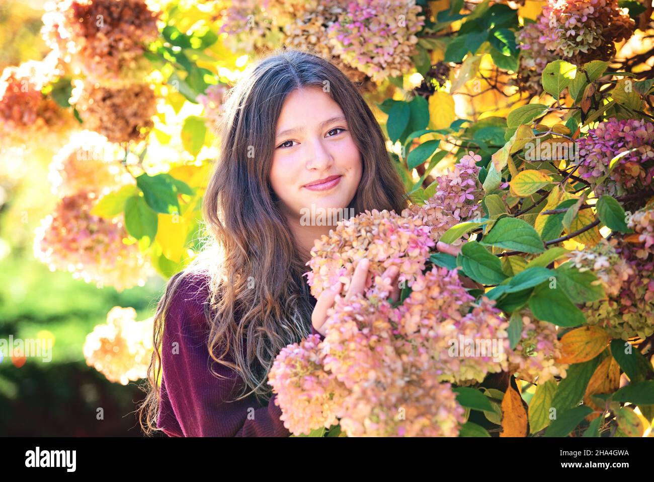 Beautiful tween girl with long hair standing by flowering tree Stock ...