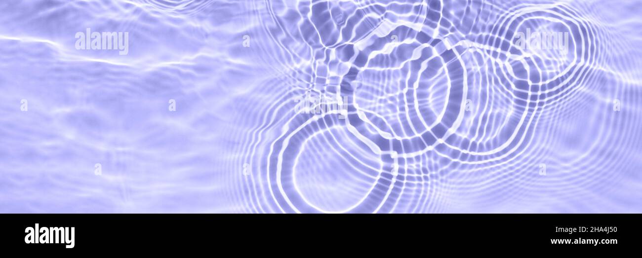 The surface of light on the purple transparent swimming pool water ...