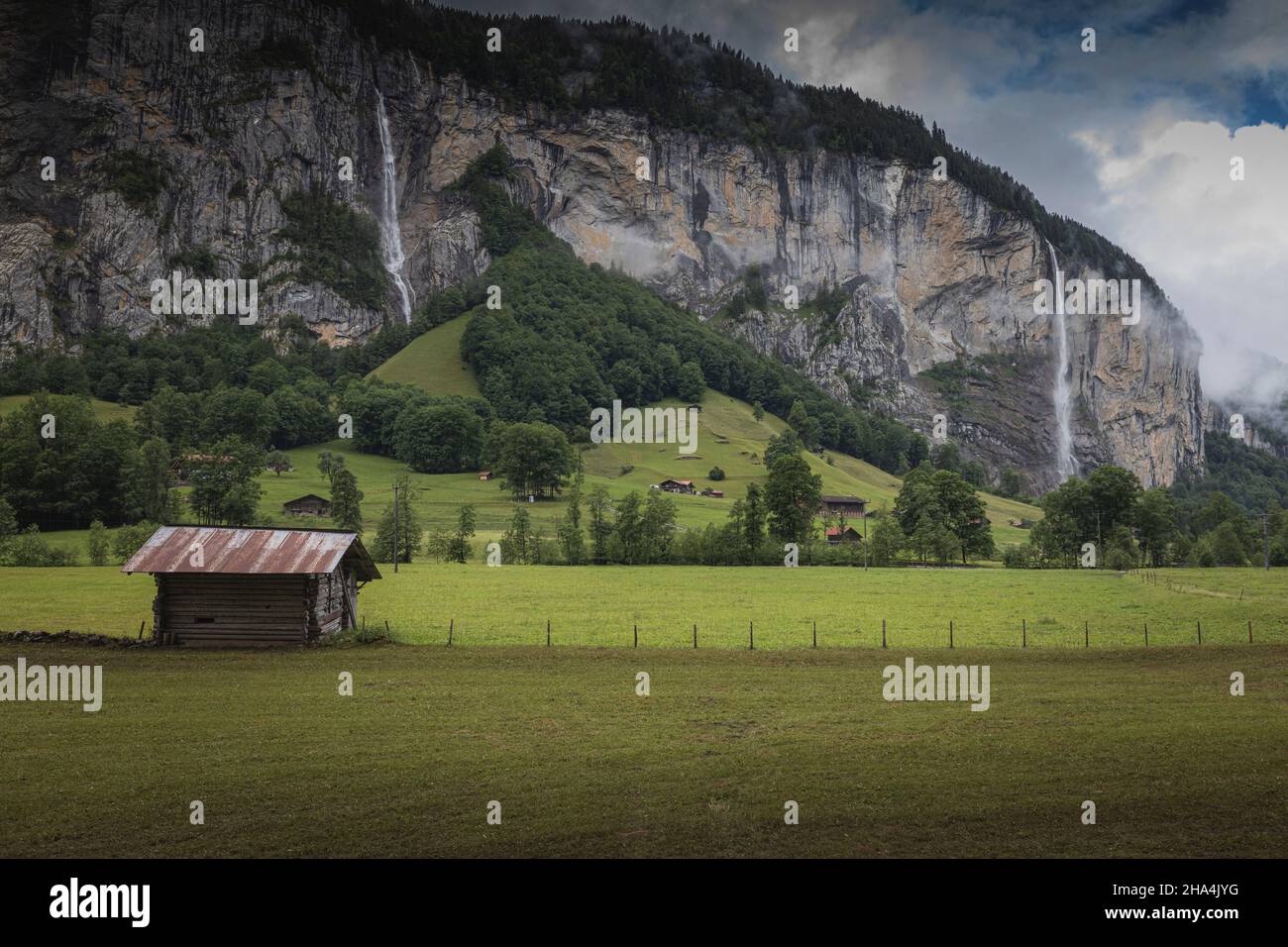 swiss valley with waterfall and traditional house Stock Photo - Alamy