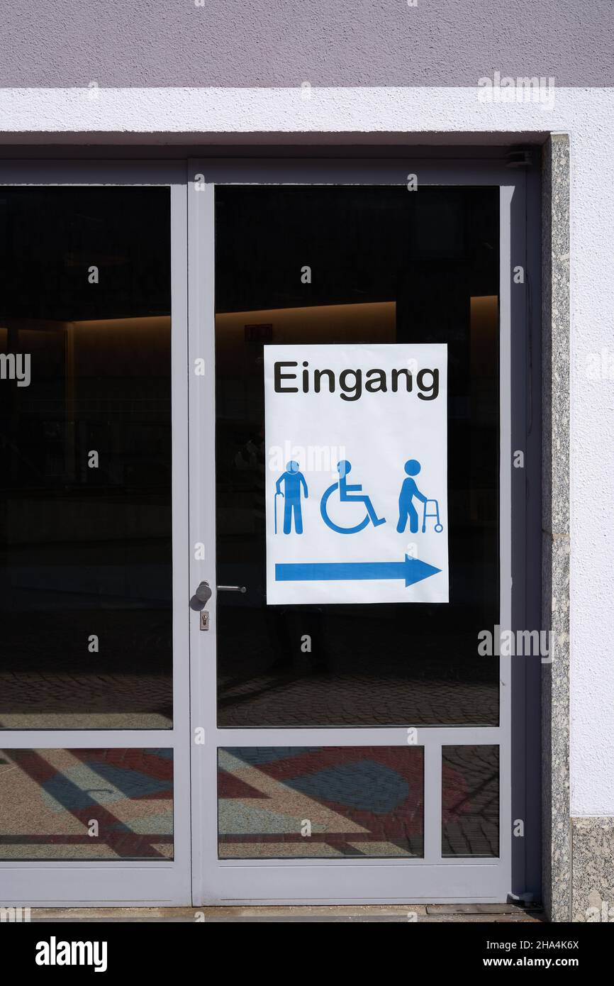 Sign on glass door saying: Entrance (germany: Eingang ). White paper ...