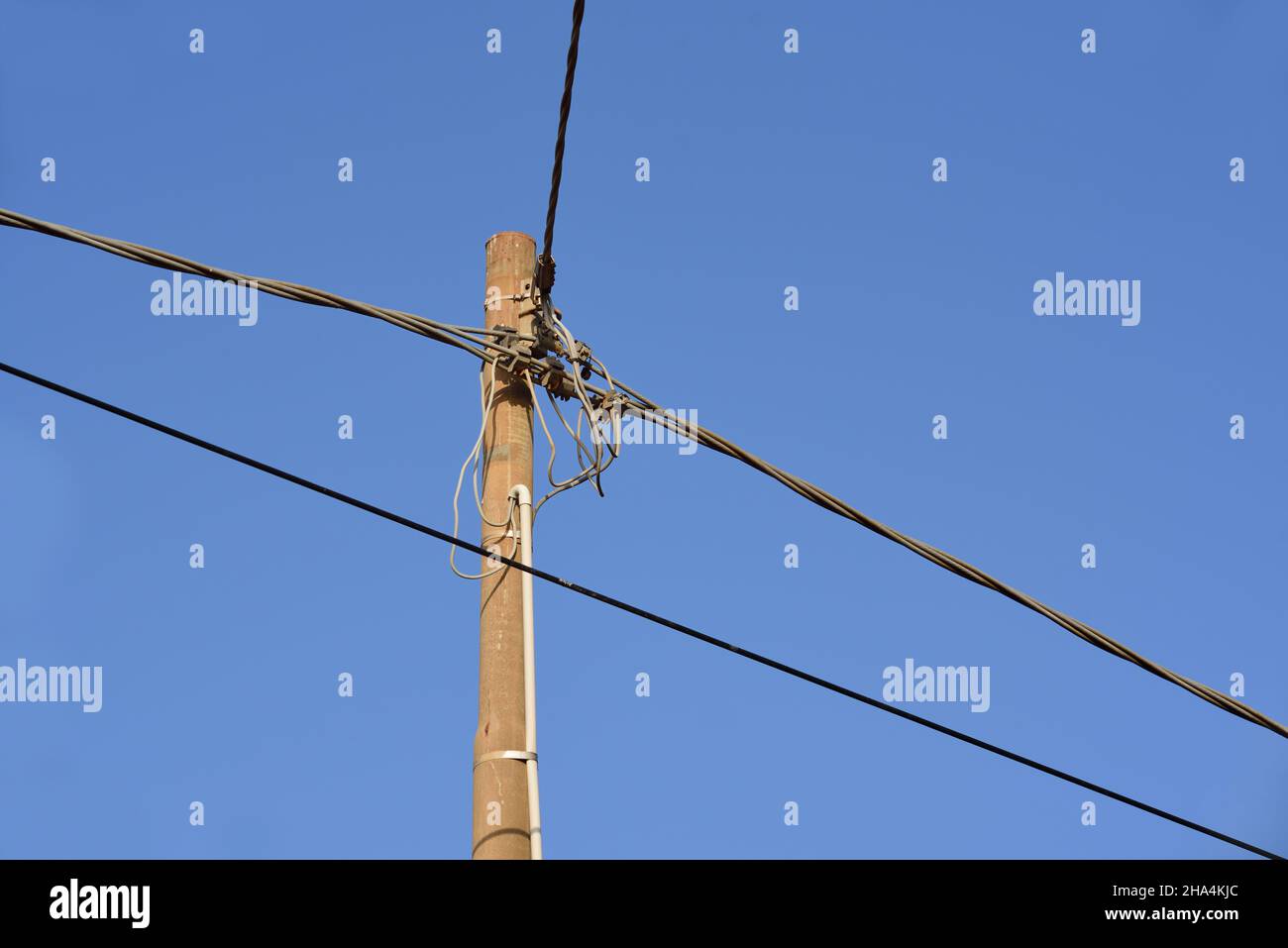 The top of a simple power pole, from which different power cables go in ...
