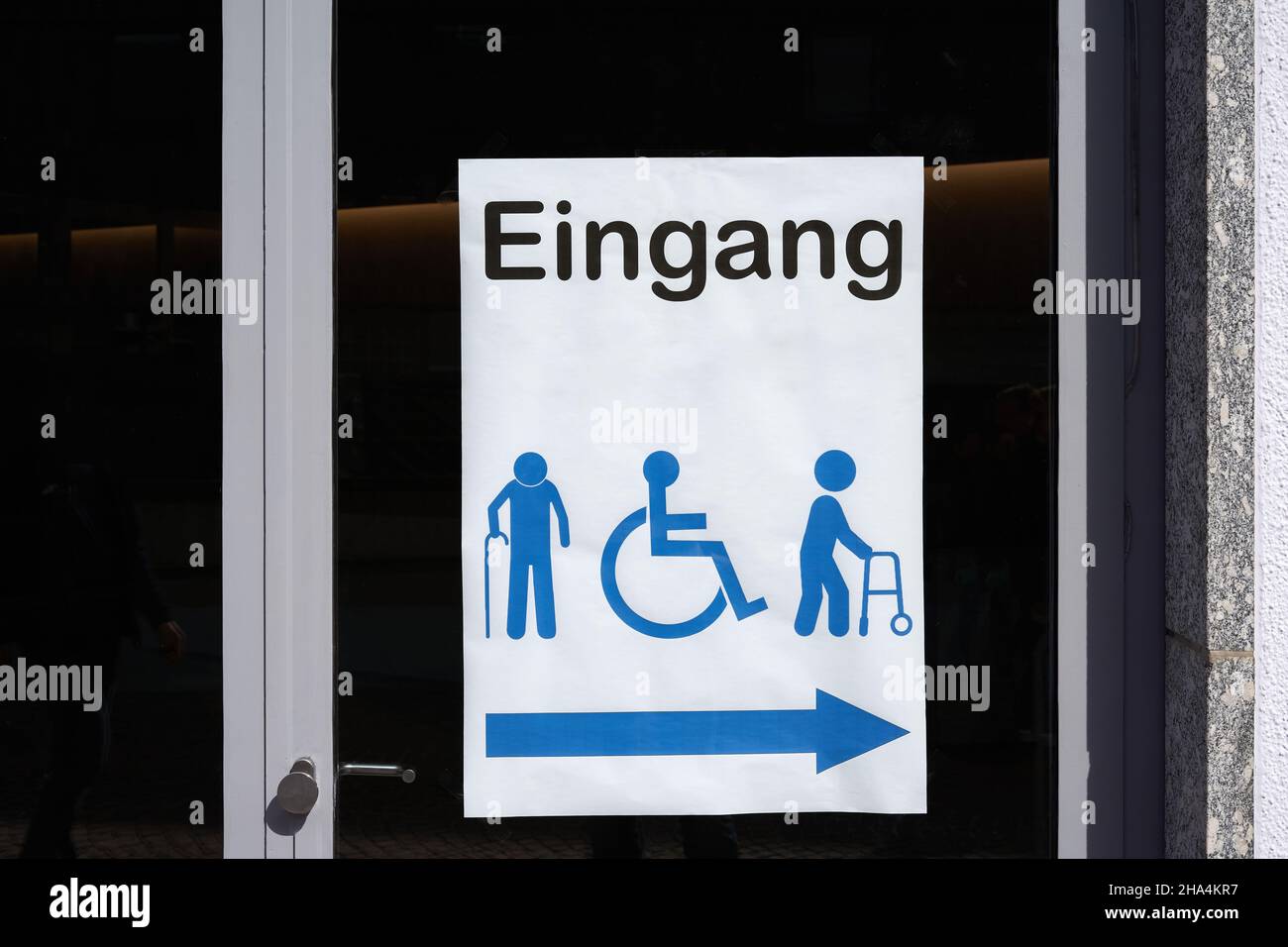 Sign on glass door saying: Entrance (germany: Eingang ). White paper ...