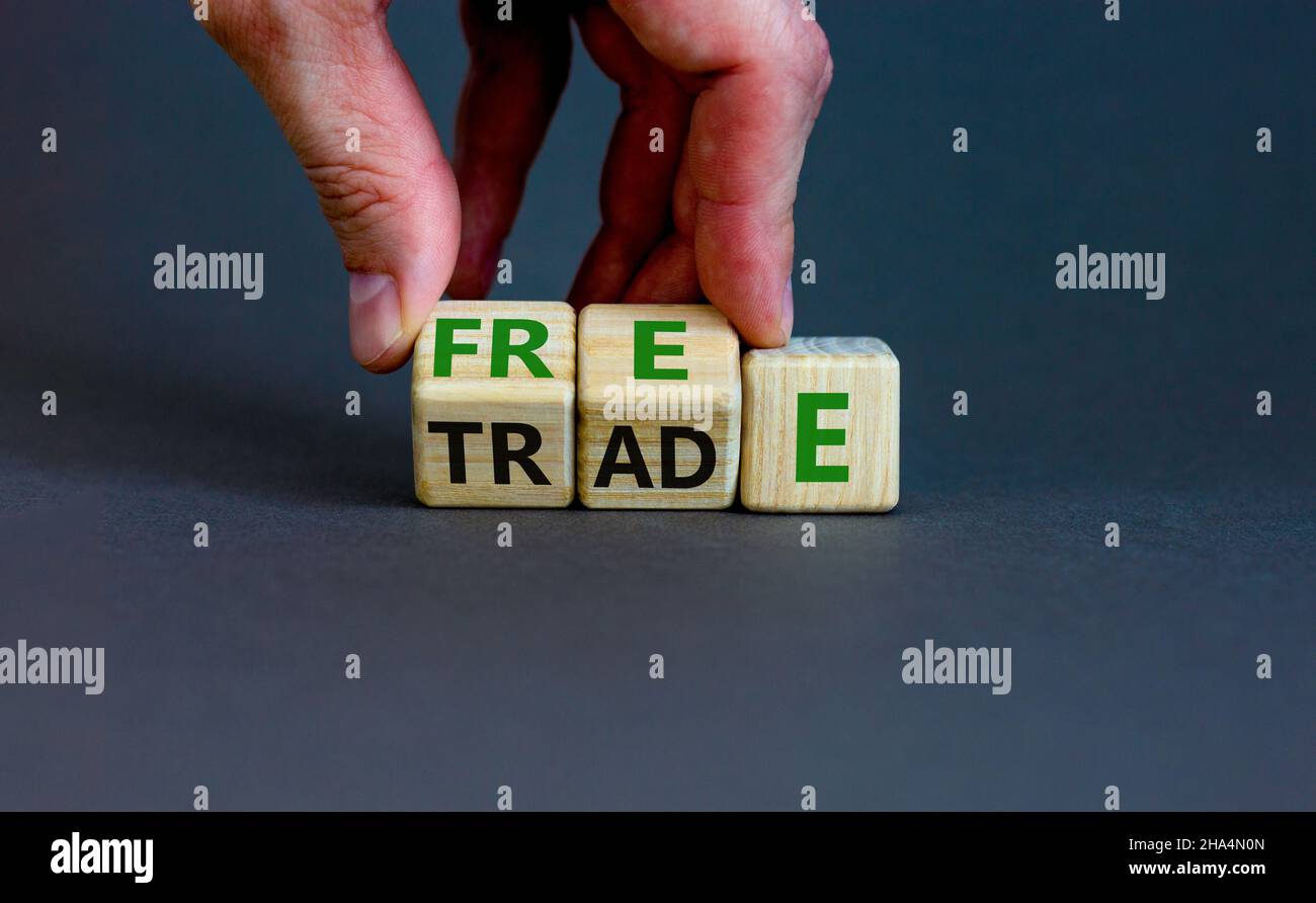 Free trade symbol. Businessman turns wooden cubes and changes the word ...