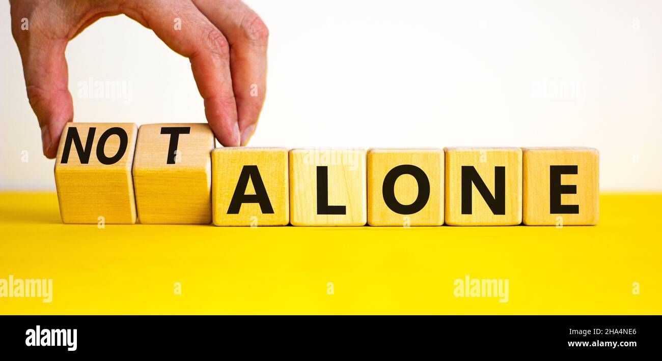 You are not alone symbol. Businessman turns wooden cubes and changes ...