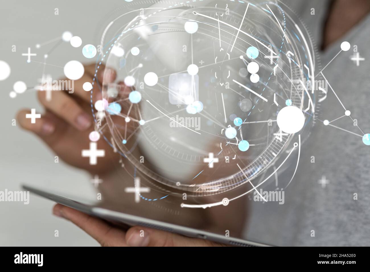 A globe hologram with interconnected dots on a businessman's tablet ...