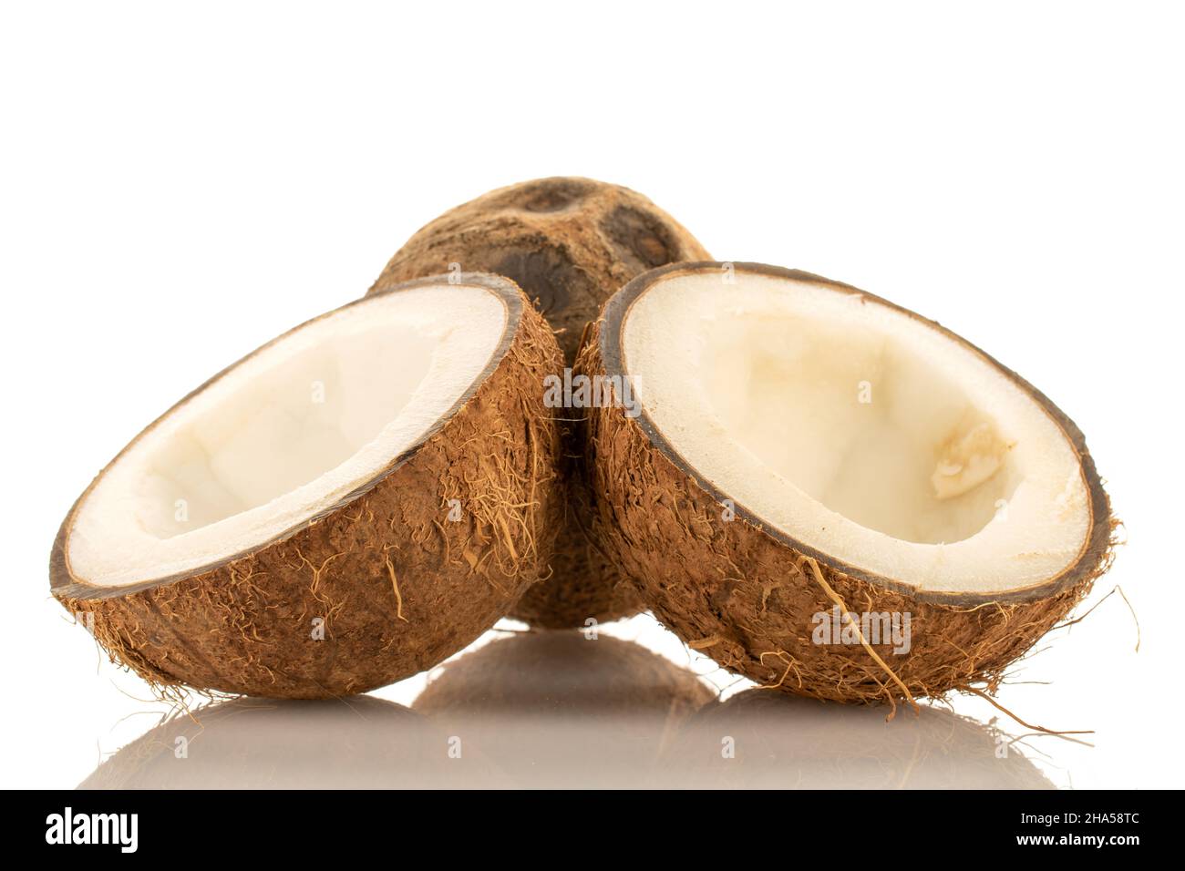 One whole and two halves of ripe organic coconut, close-up, isolated on ...