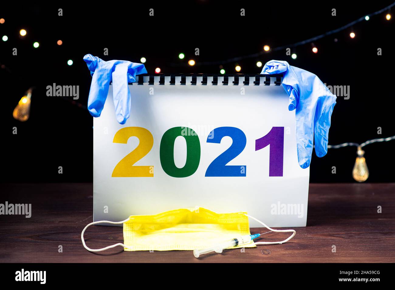 2021 medicine concept. numbers on a sheet of paper with a medical mask, gloves, against the ...