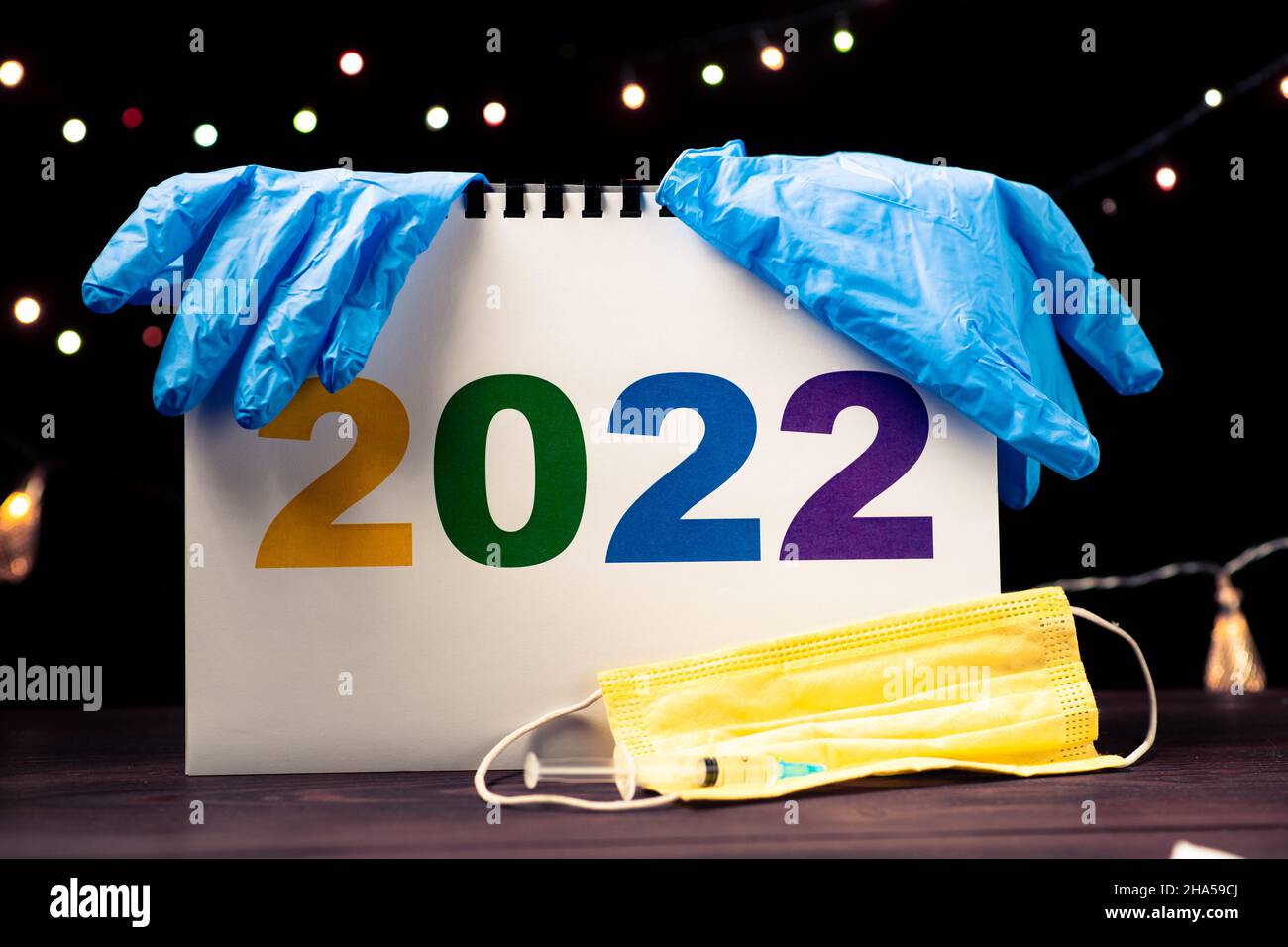 2022 medicine concept. numbers on a sheet of paper with a medical mask, gloves, against the ...
