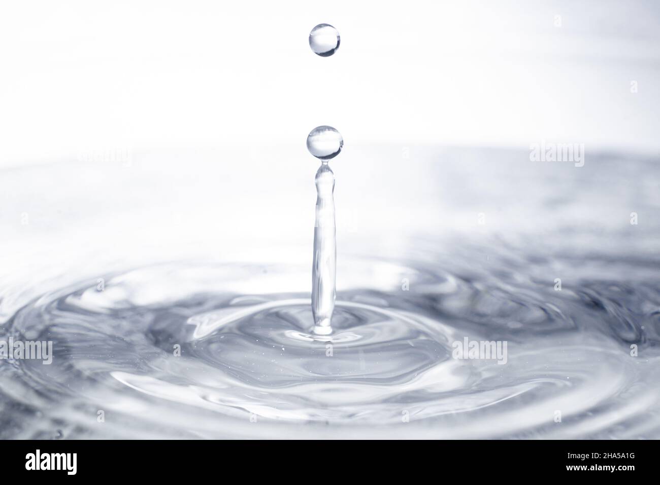 Water drop falls on water surface with waves close-up Stock Photo - Alamy