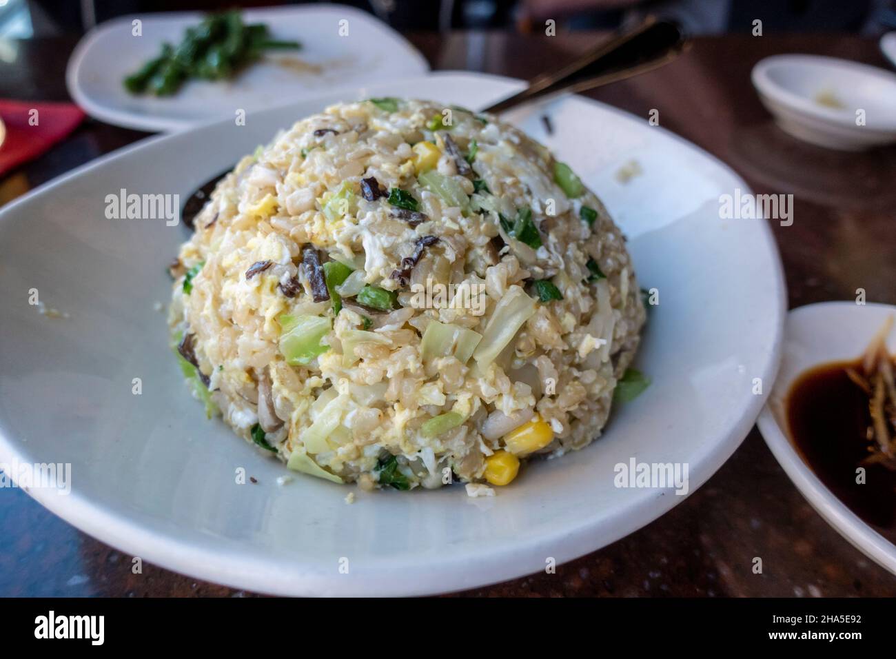 View of a round scoop of vegetable and mushroom fried rice on a small ...