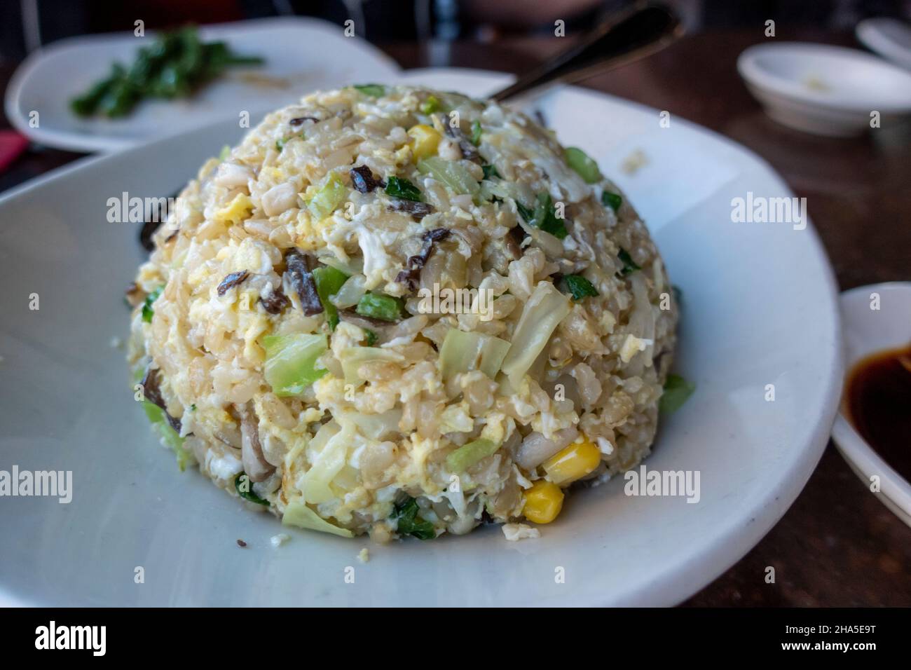 View of a round scoop of vegetable and mushroom fried rice on a small ...
