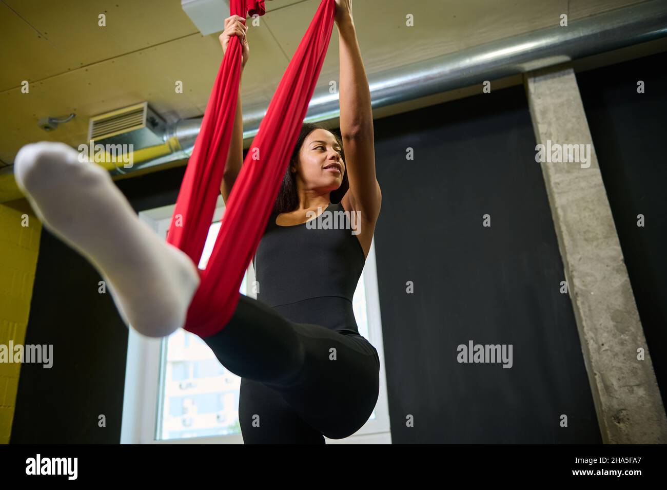 Bottom view of a young African slim body woman stretching her legs ...