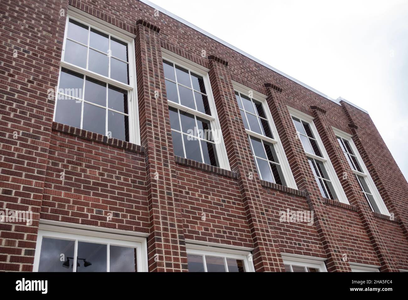 Low angle view of a red brick school building, with lots of windows on ...