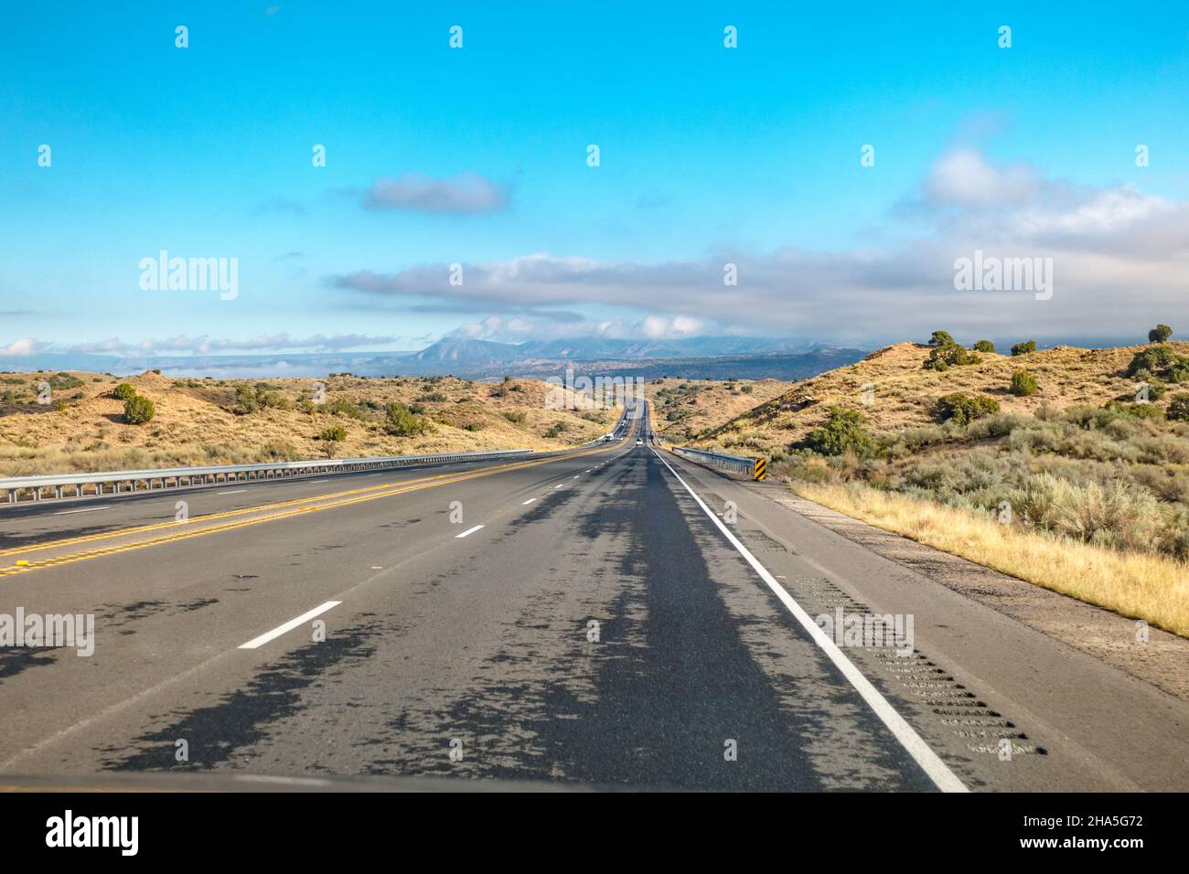 Long rural road under a bright blue sky Stock Photo - Alamy