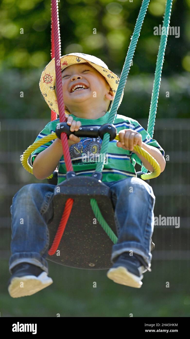 toddler,2 years,multiethnic,eurasian,laughs,swings on a children's ...
