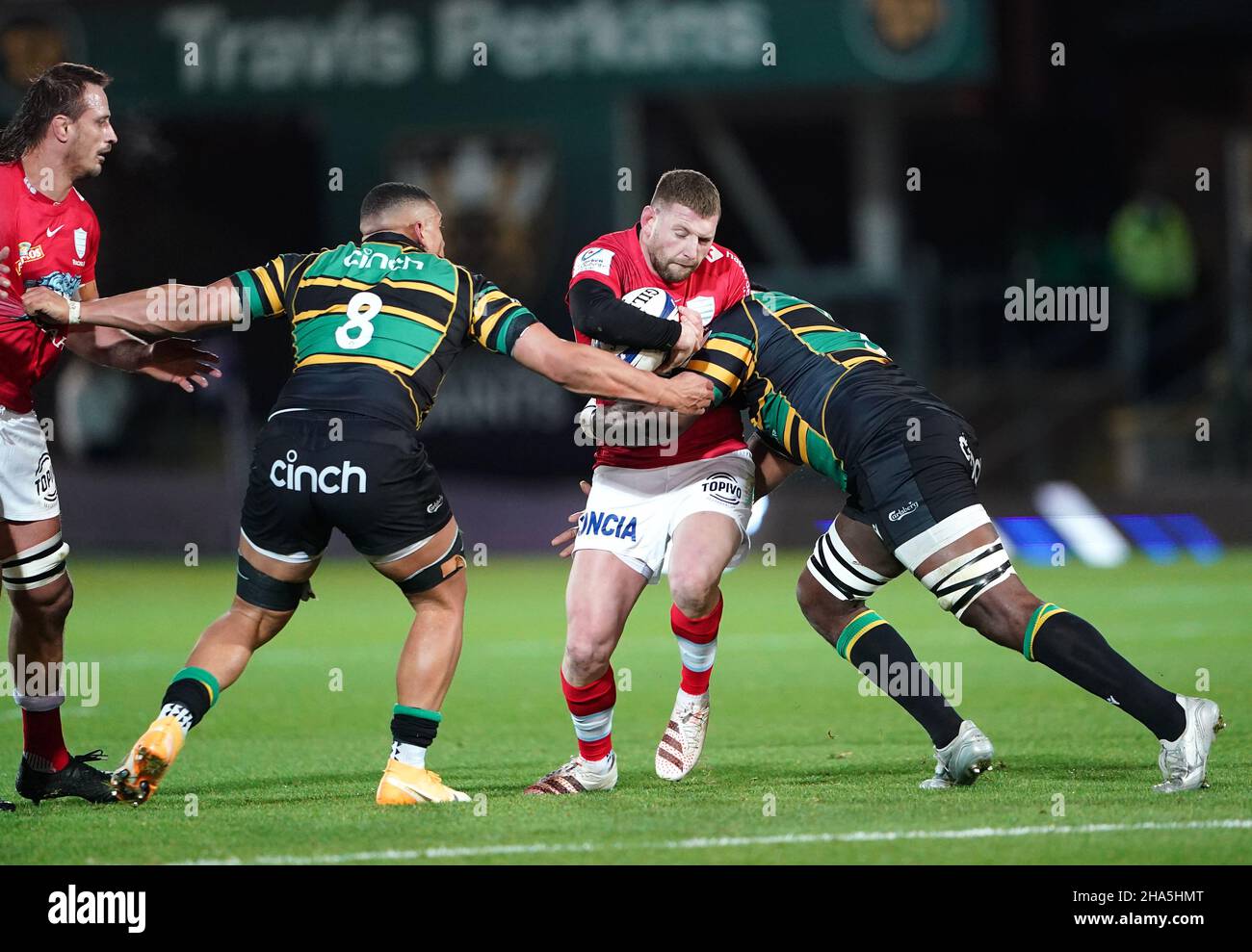 Racing 92's Finn Russell (centre) tackled by Northampton Saints' Juarno ...