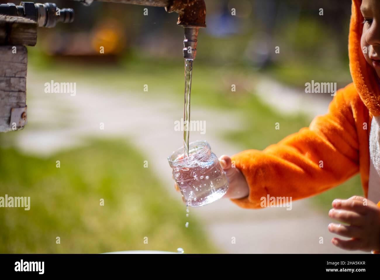 faceless child plays with water in water tap outdoor Stock Photo - Alamy