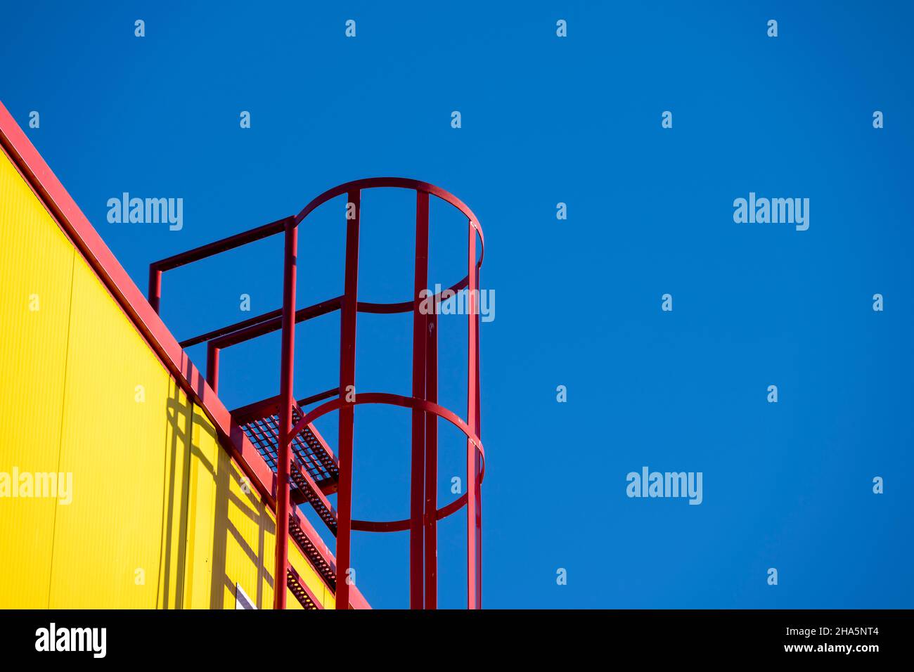 colorful industrial architecture,yellow facade,red ladder,blue sky ...