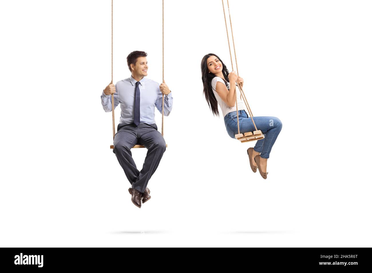Man sitting on a swing and looking at a beautiful young woman swinging ...