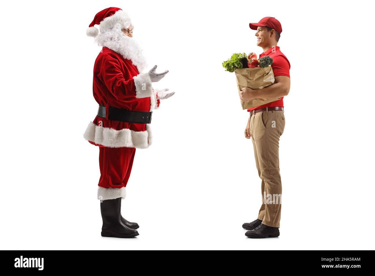 Full length profile shot of santa claus talking to a delivery man with ...