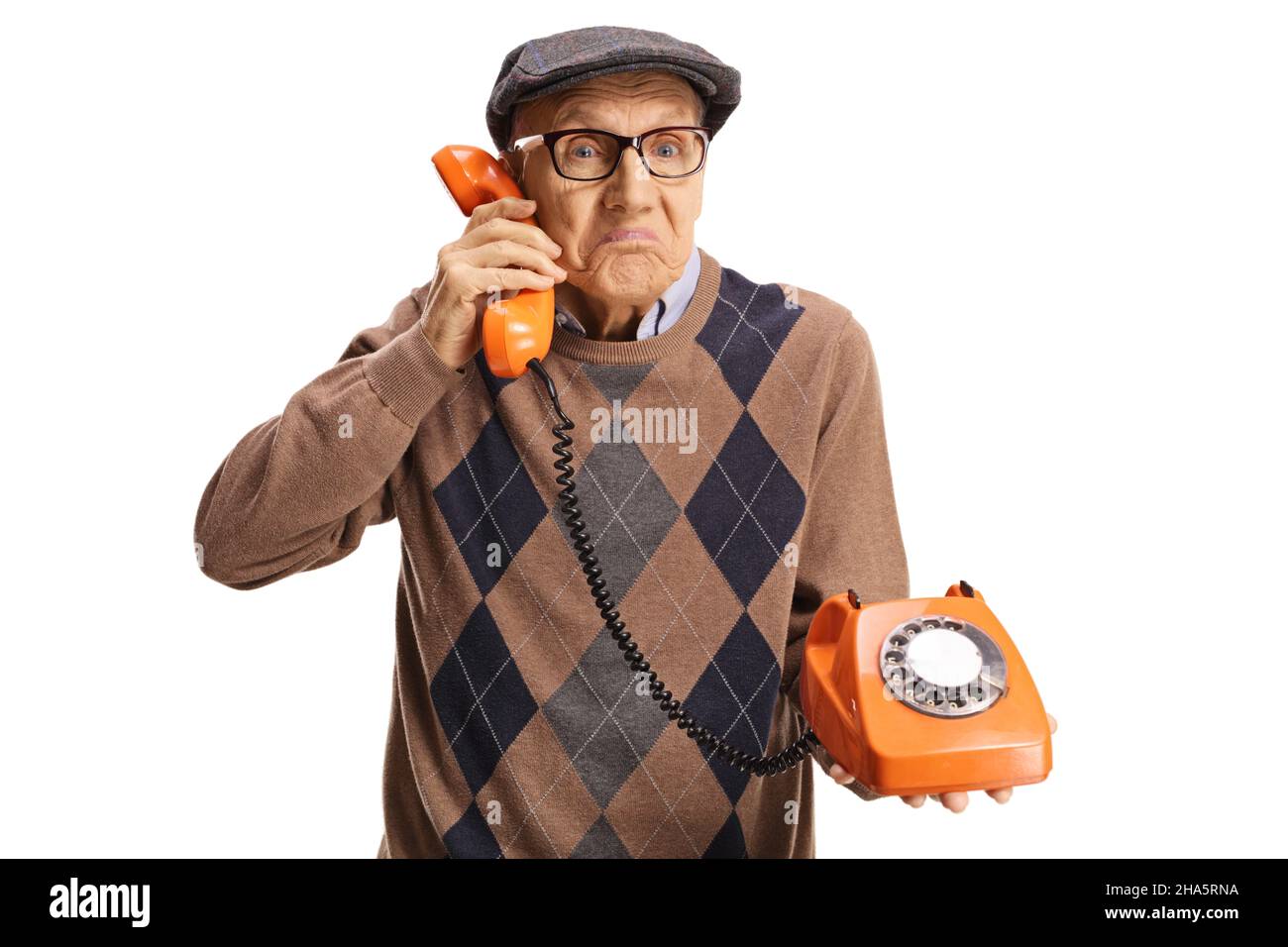 Confused Elderly Man Holding A Vintage Rotary Phone And Looking At