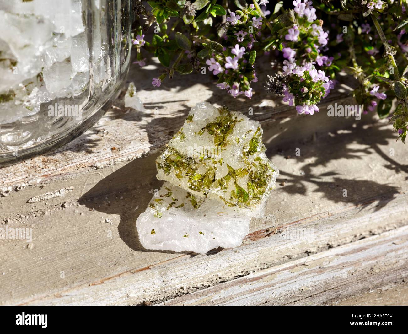 thyme candies on an old wooden window sill,behind them a bouquet of ...