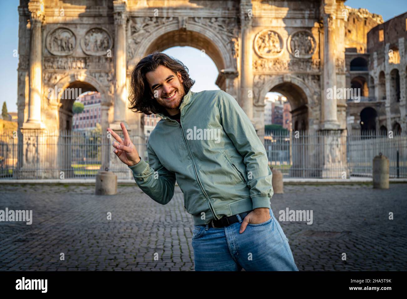 Happy moment in Rome. Young smiling man posing for a picture doing the ...