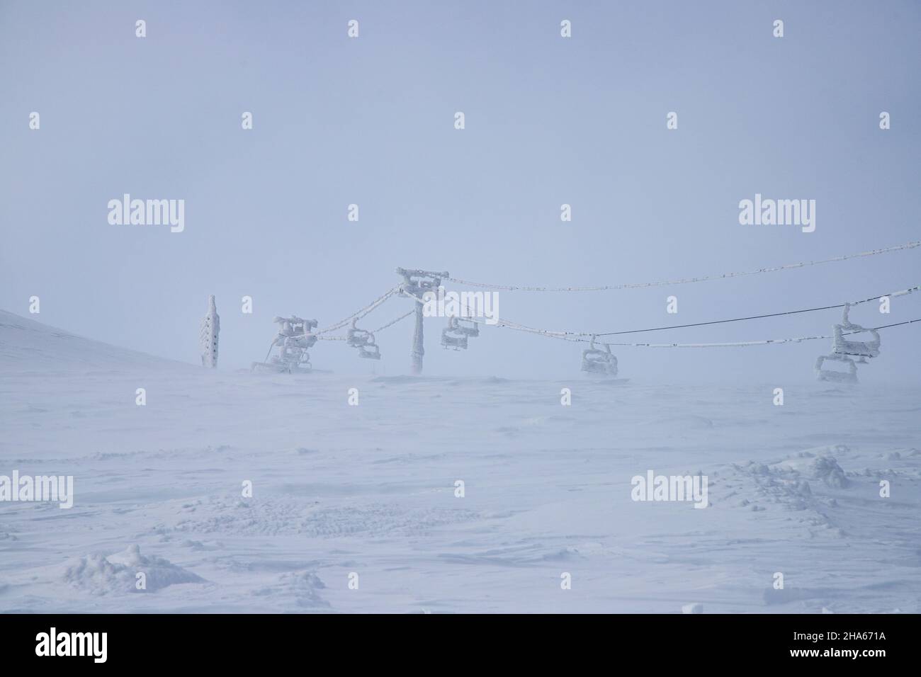 Landscape of ropeways covered in the snow on hills under a cloudy sky ...