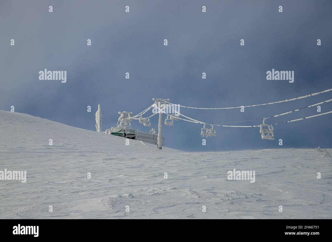 Landscape of ropeways covered in the snow on hills under a cloudy sky ...
