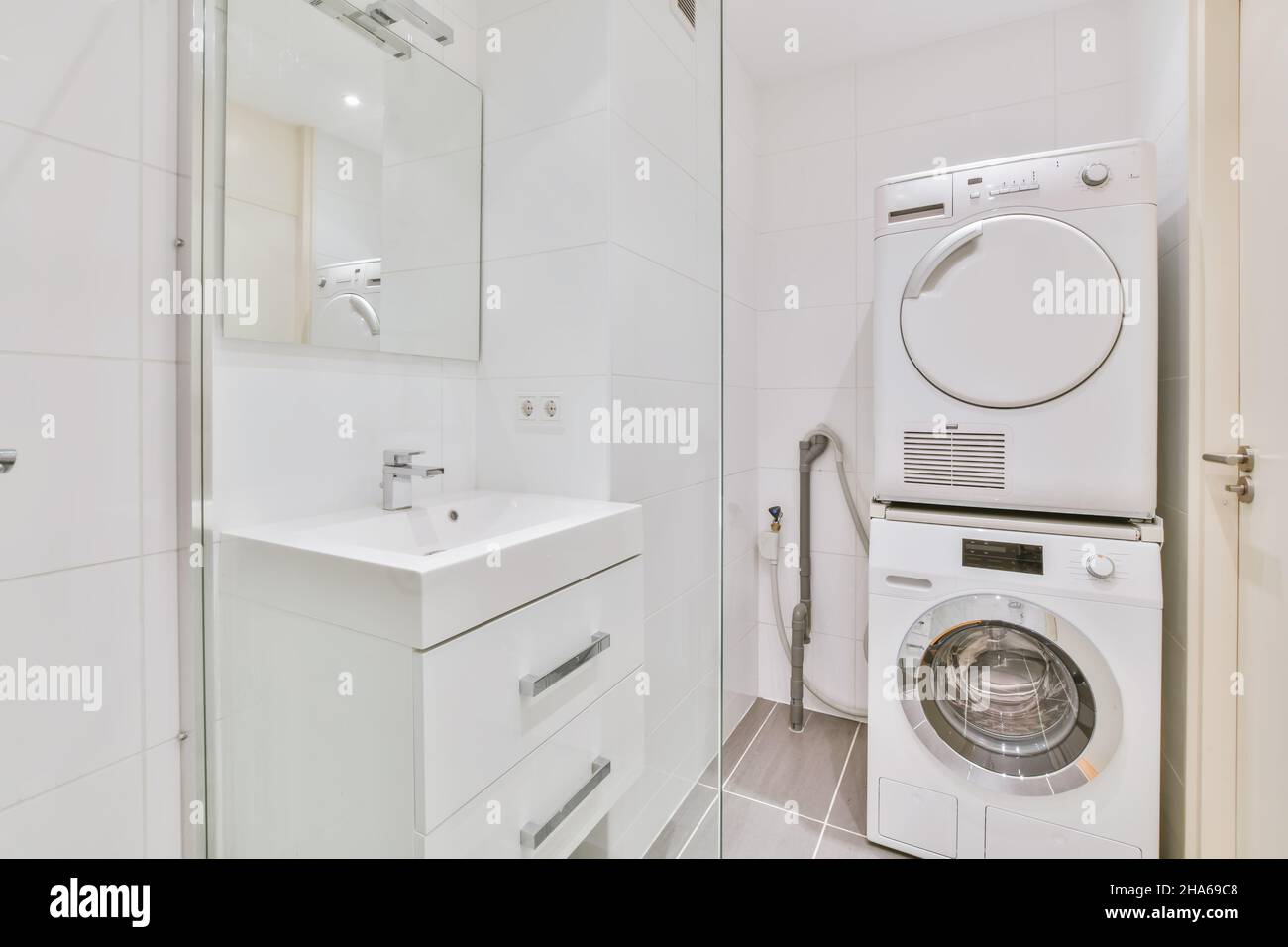 Bright bathroom with washing machine and tumble dryer Stock Photo - Alamy