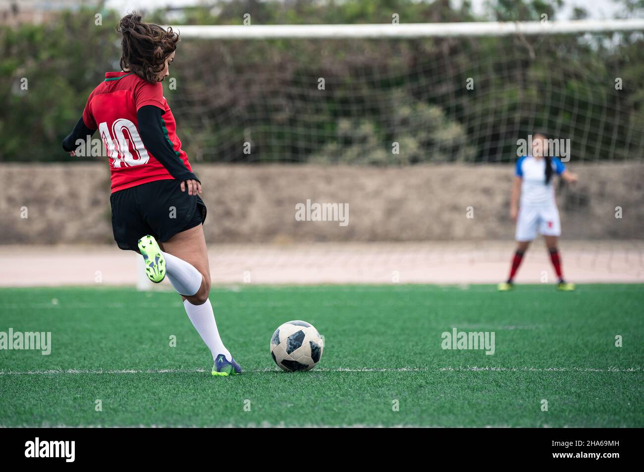 Female soccer player kicks the ball towards the goal in a stadium Stock ...