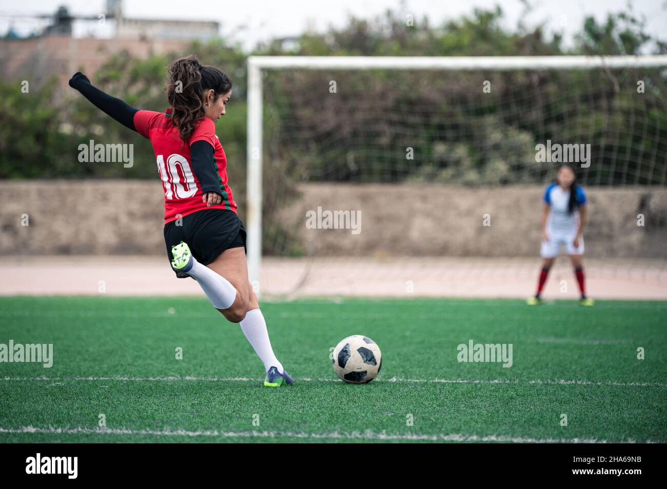 female soccer player kicks the ball towards the goal in a stadium Stock ...
