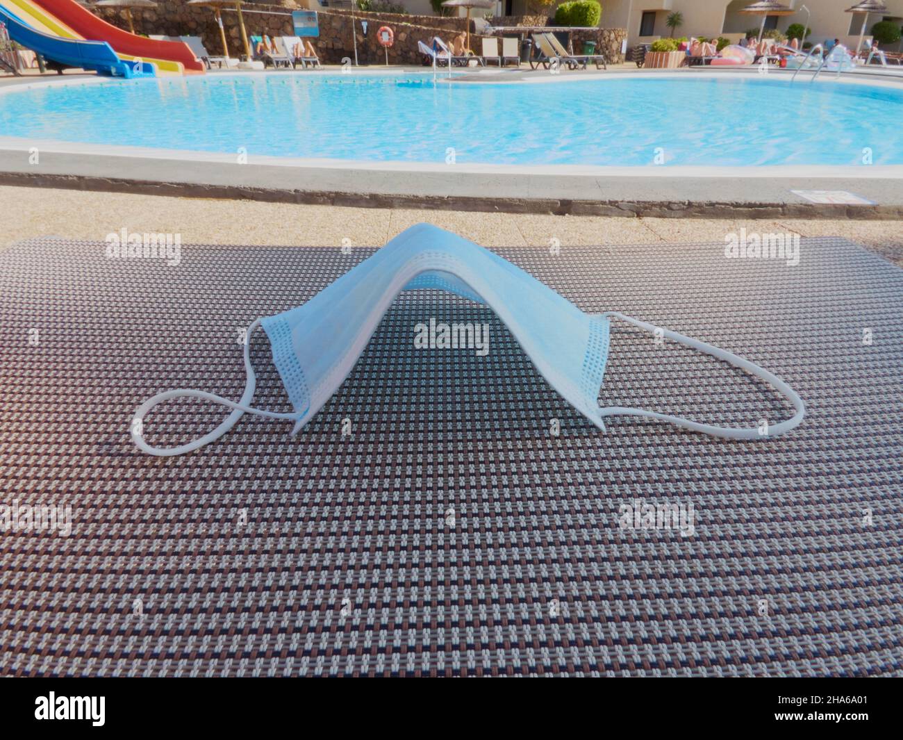 surgical mask or face mask, in a hammock by the pool Stock Photo - Alamy