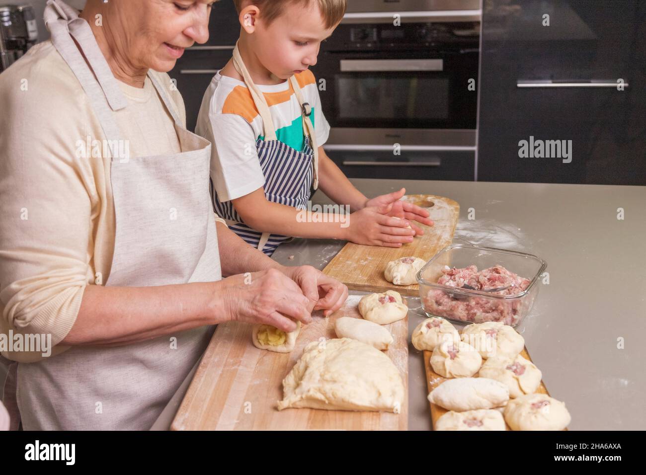 grandmother and little boy cooking their favorite dish in the kitchen ...