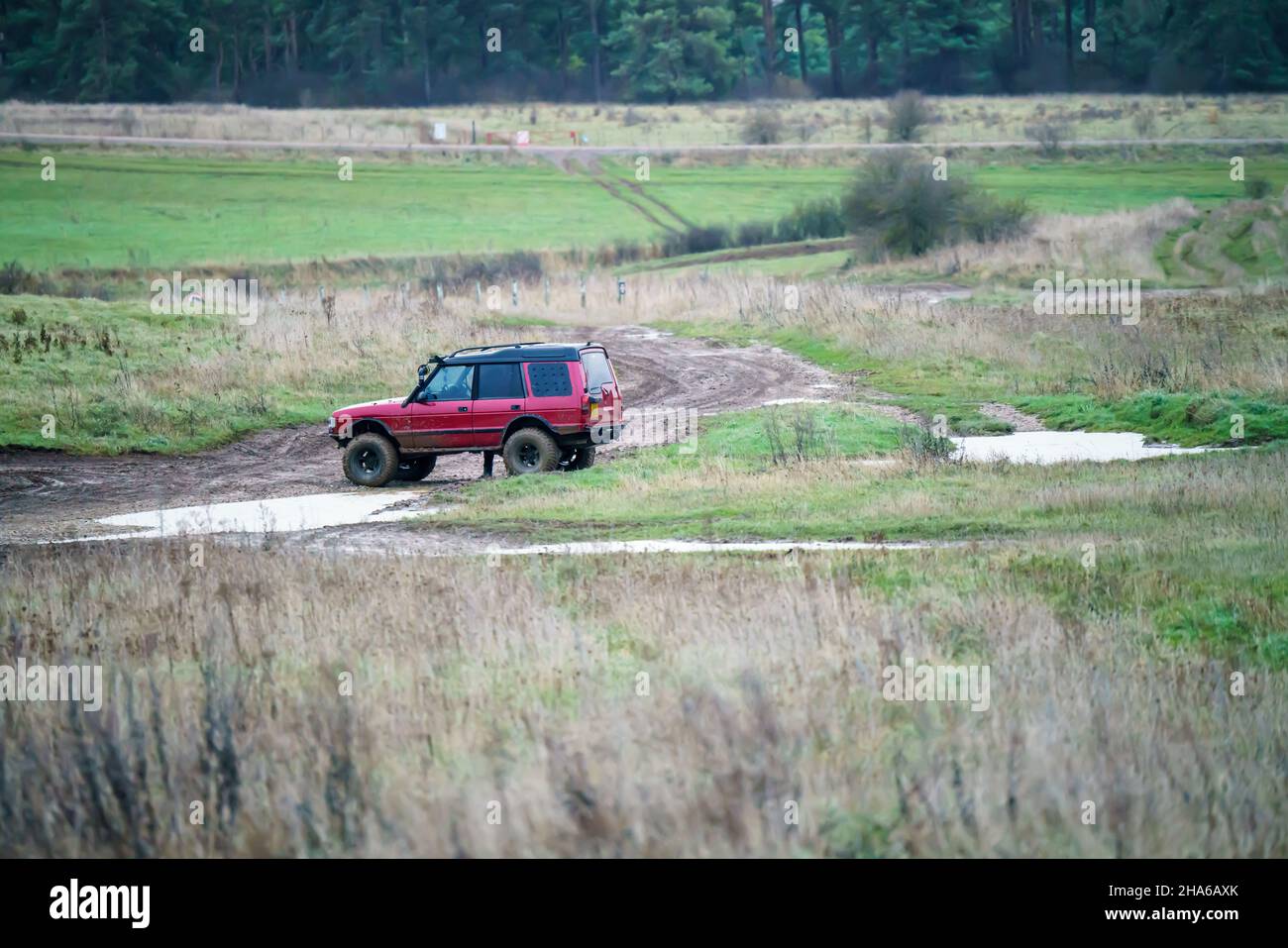 4x4 off-road vehicle driving across mud and water-logged terrain ...