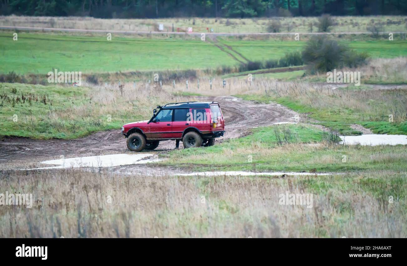 4x4 off-road vehicle driving across mud and water-logged terrain ...