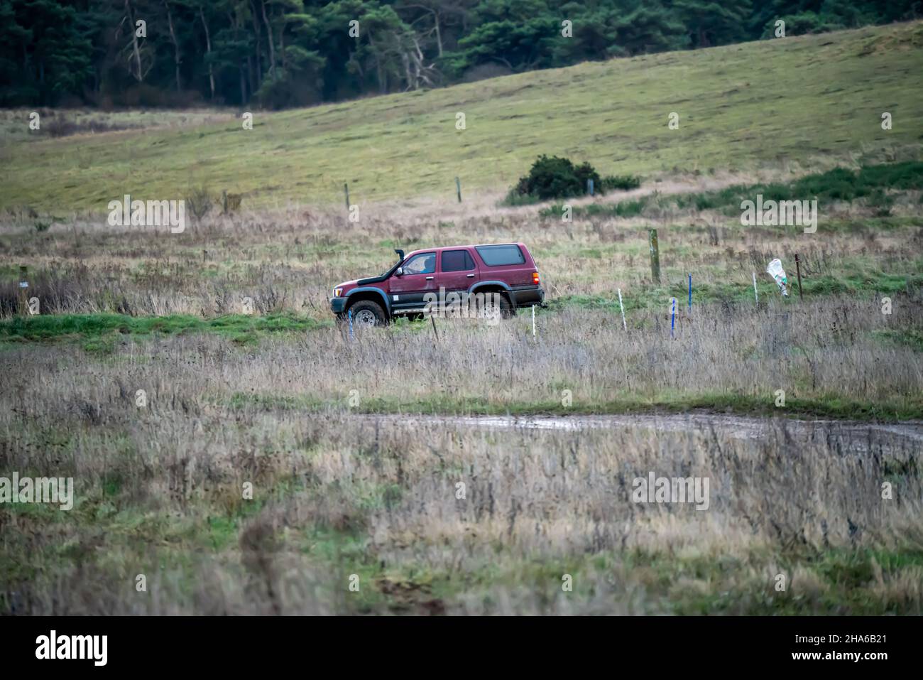 4x4 off-road vehicle driving across mud and water-logged terrain ...