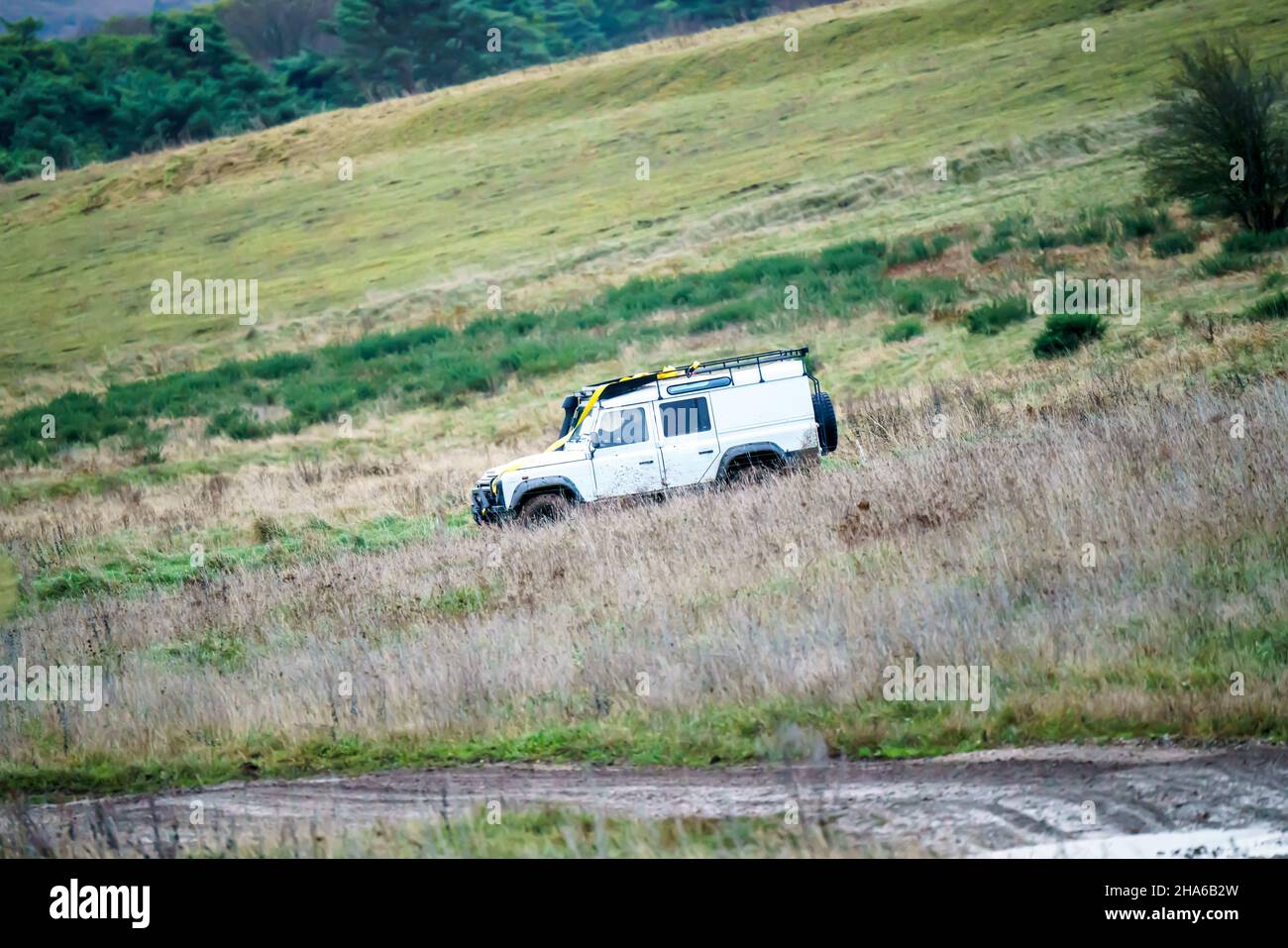 4x4 off-road vehicle driving across mud and water-logged terrain ...