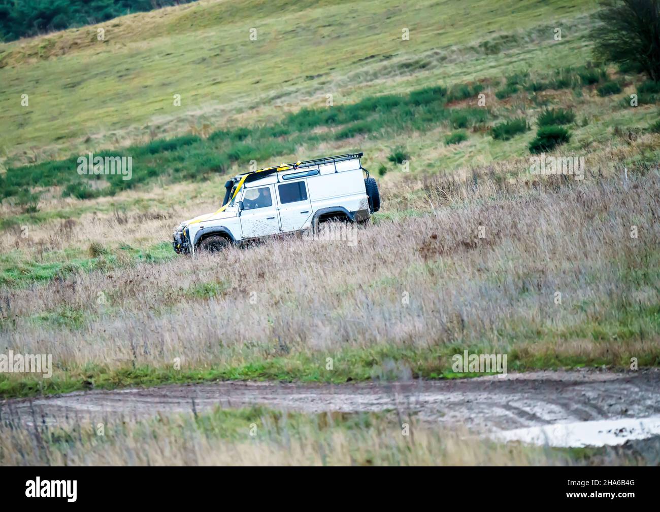 4x4 off-road vehicle driving across mud and water-logged terrain ...