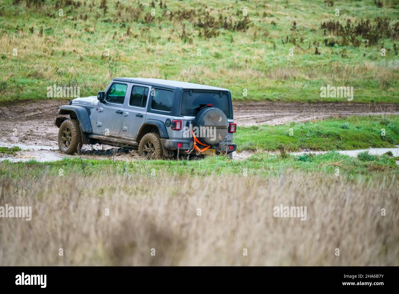 4x4 off-road vehicle driving across mud and water-logged terrain ...