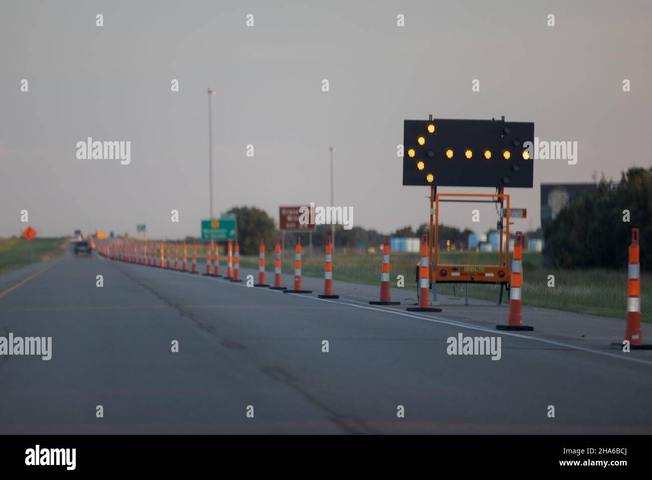 Road construction on a highway with an illuminated arrow sign pointing ...