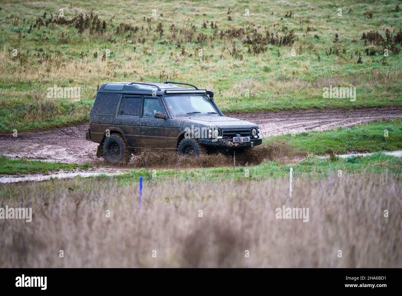 4x4 off-road vehicle driving across mud and water-logged terrain ...
