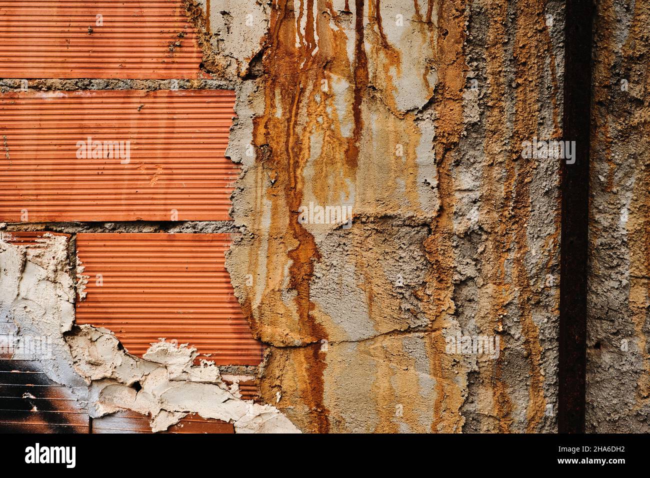 Detail of brick wall covered with cement stained with rust ...