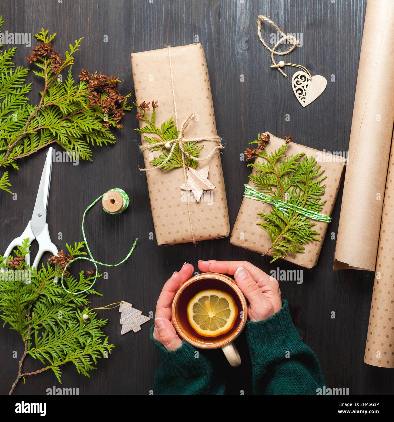 Wrapping Christmas gifts in craft paper, top view Stock Photo - Alamy