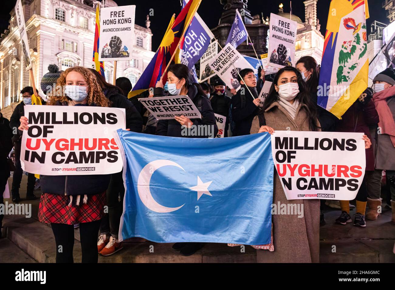 Protestors hold the Uyghur flag and placards that read 'Millions of ...