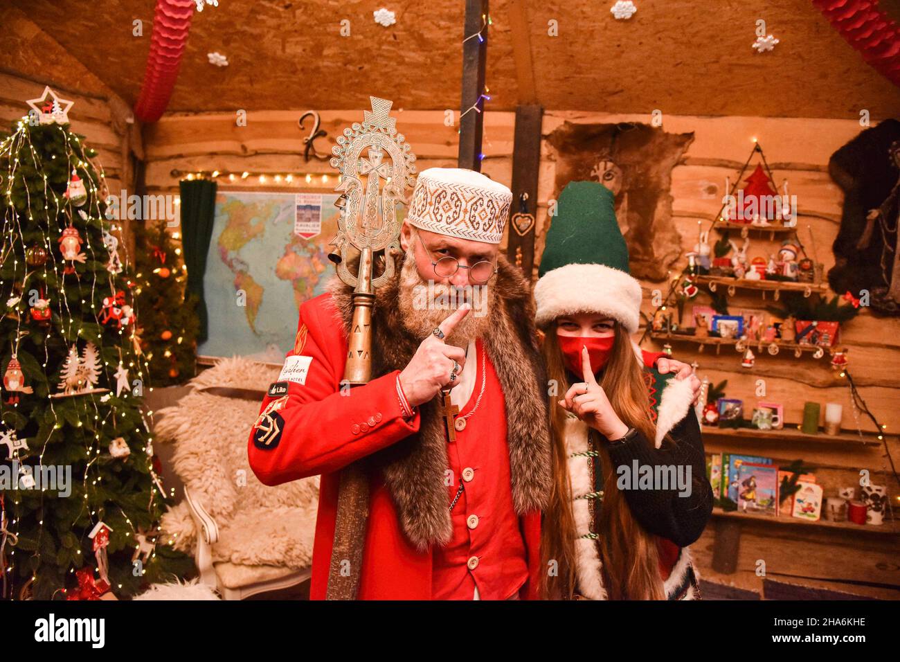 A man dressed as St. Nicholas poses for a photo with a young lady at ...