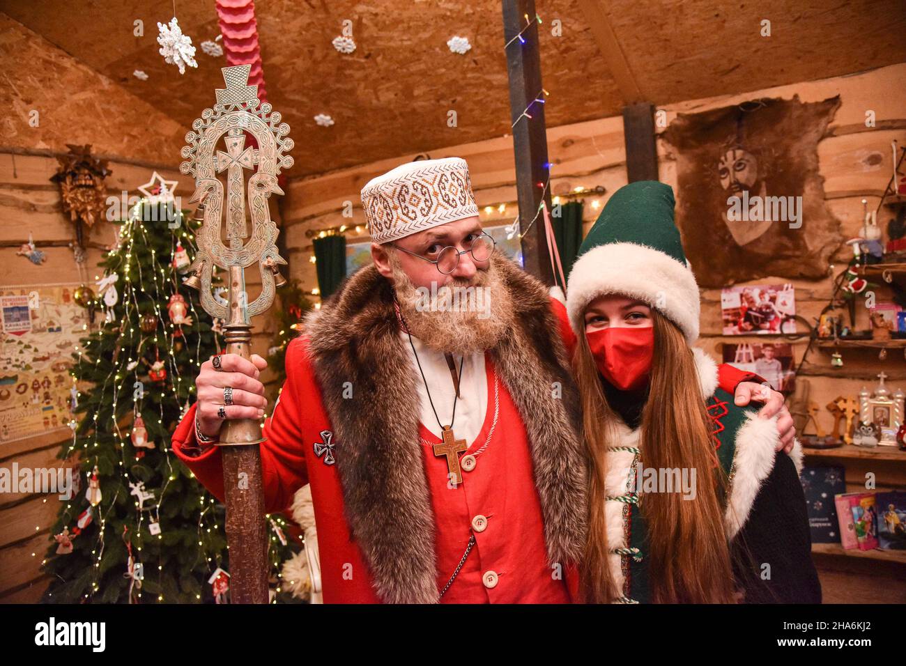 A man dressed as St. Nicholas poses for a photo with a young lady at ...