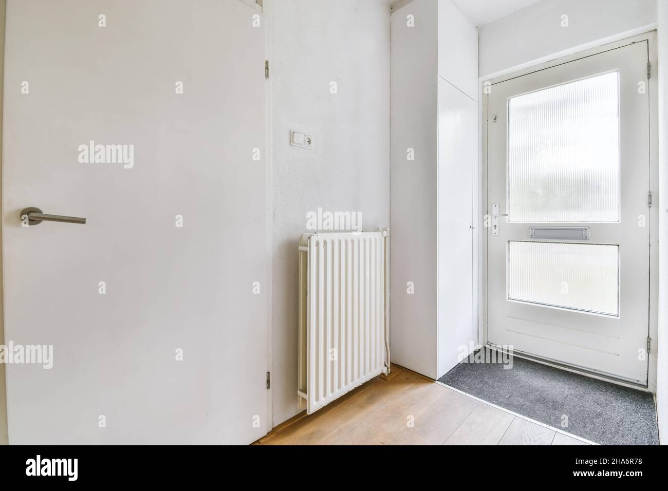 Apartment entrance door with radiator and parquet floor Stock Photo - Alamy